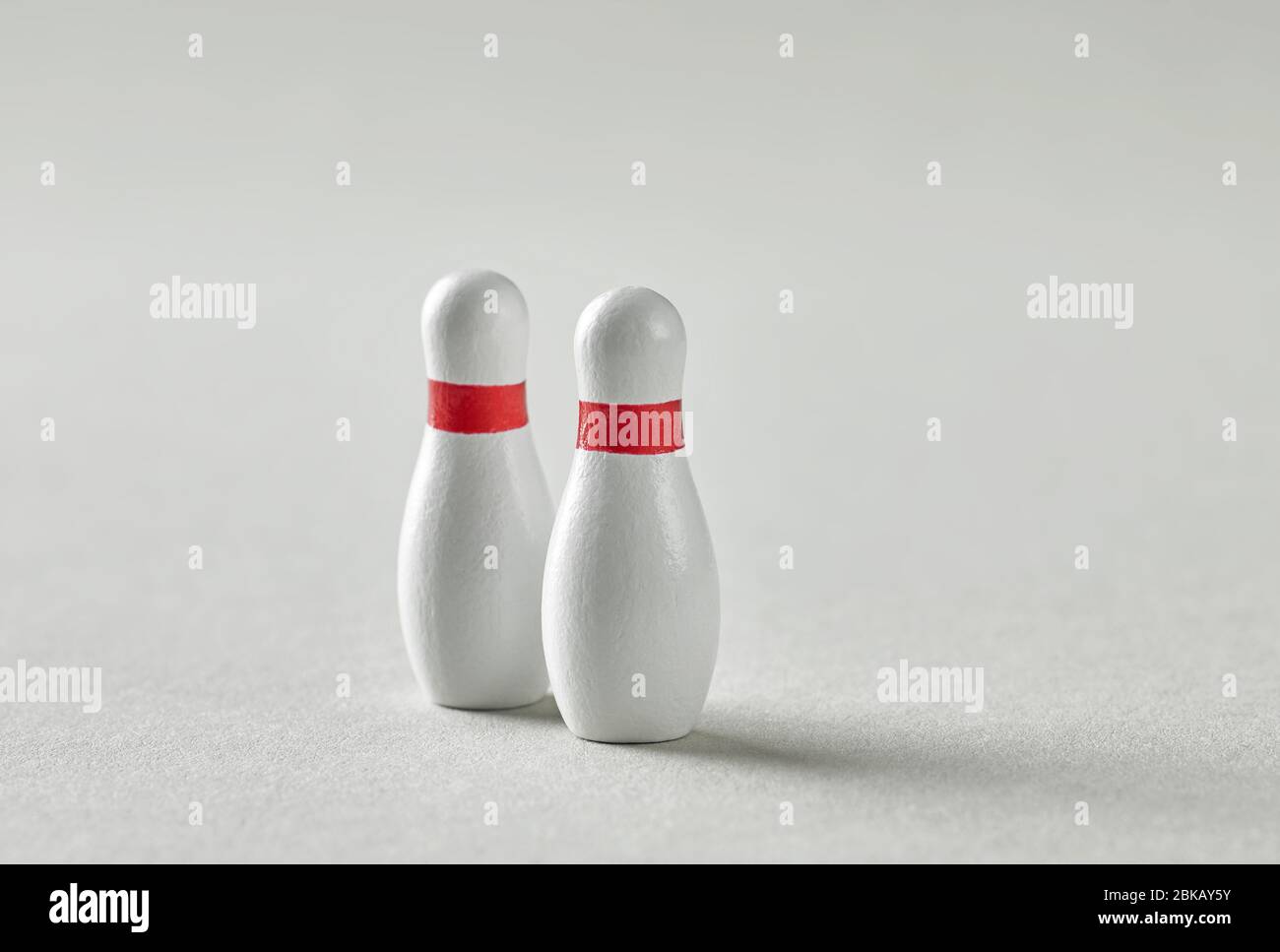 two bowling pins on grey paper background Stock Photo - Alamy