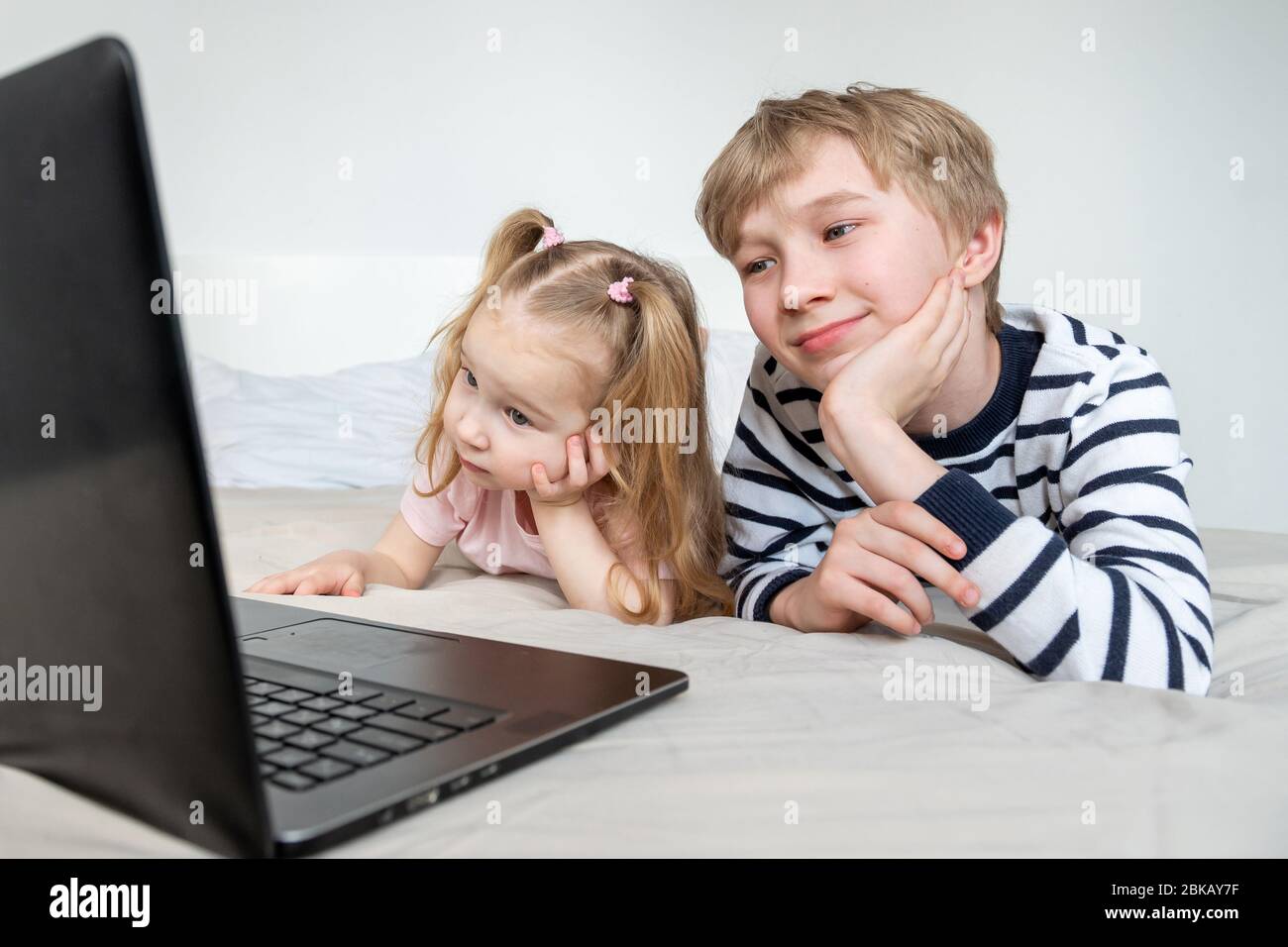 Two kids girl and boy using laptop computer at home and smiling Stock ...