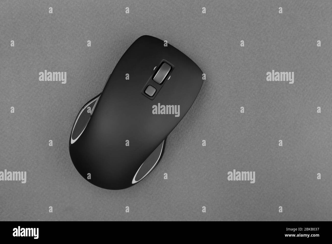 Wireless computer mouse in black on a gray background. View from above ...