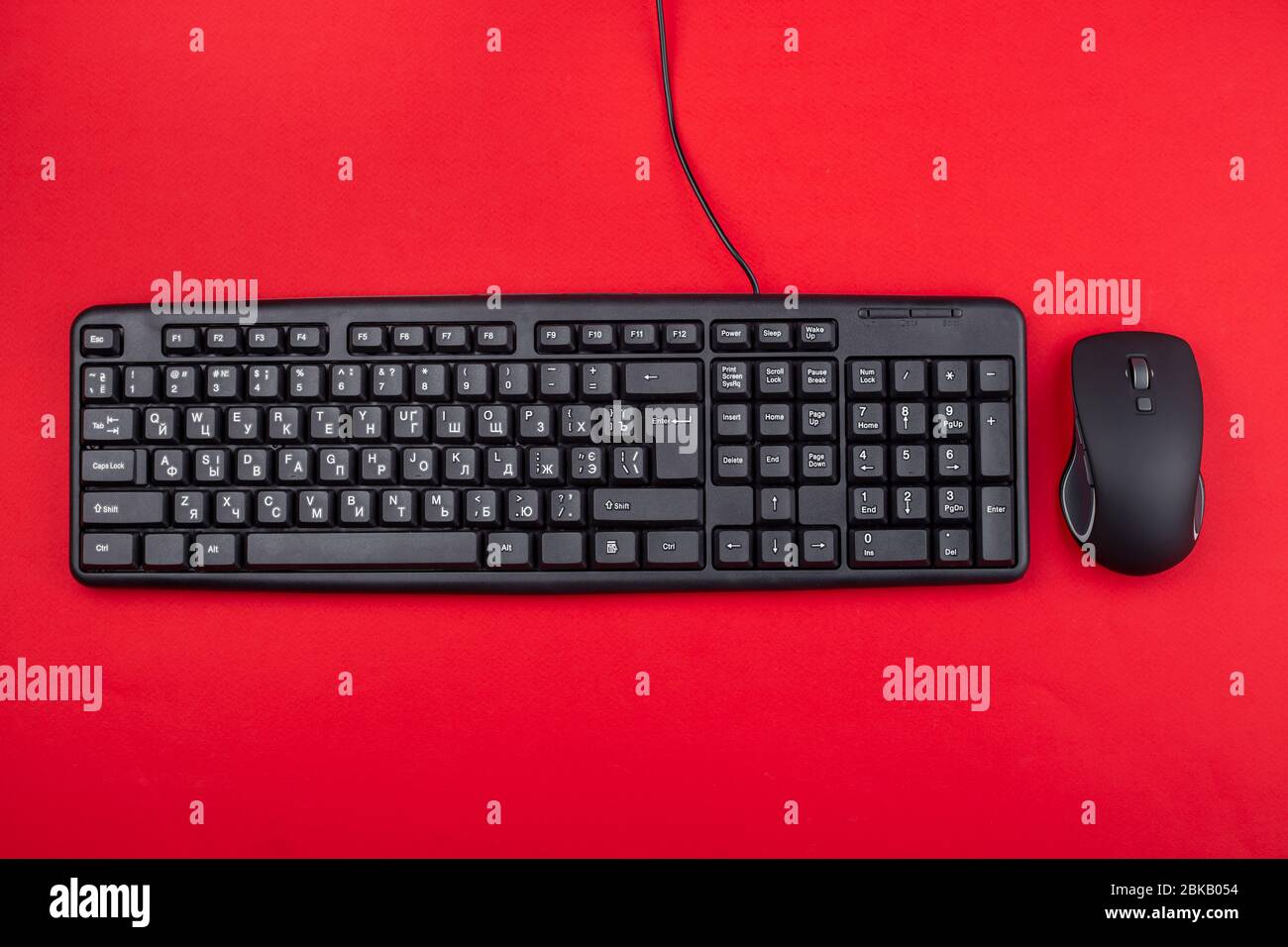 Computer mouse and keyboard on a reddish background. Top view. Computer ...