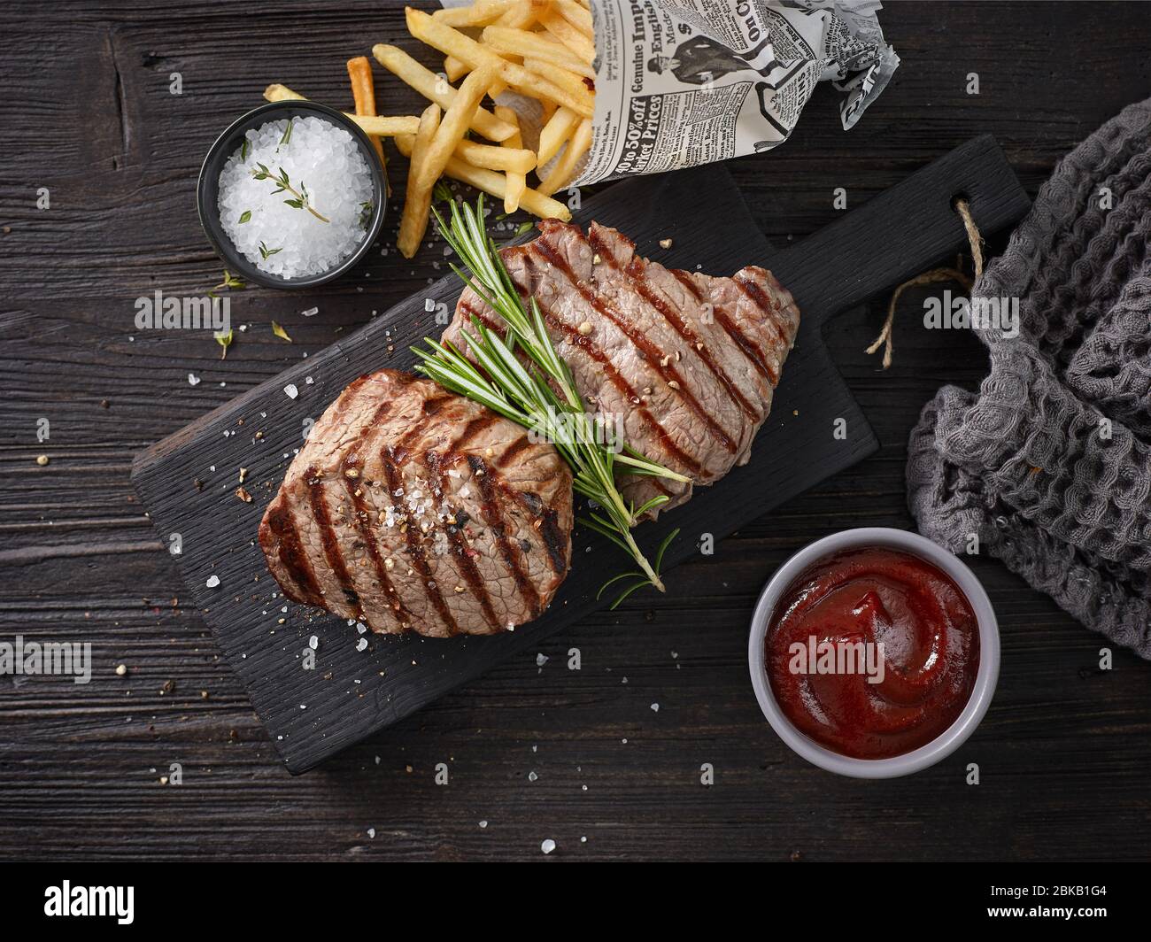 grilled beef steaks on dark wood table, top view Stock Photo - Alamy