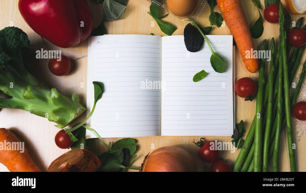 Open notebook surrounded by vegetables. Grocery list with vegetables ...