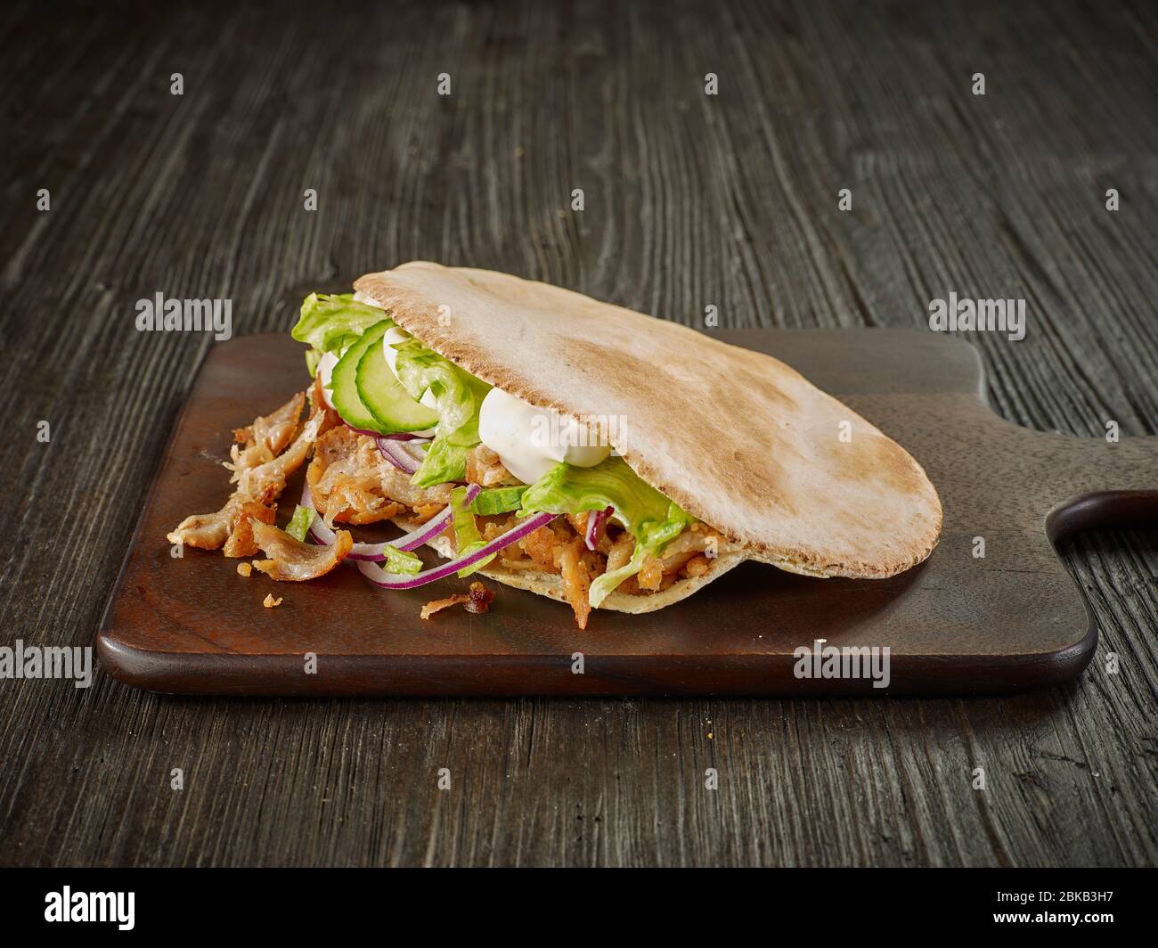 doner kebab on dark wooden kitchen table Stock Photo - Alamy