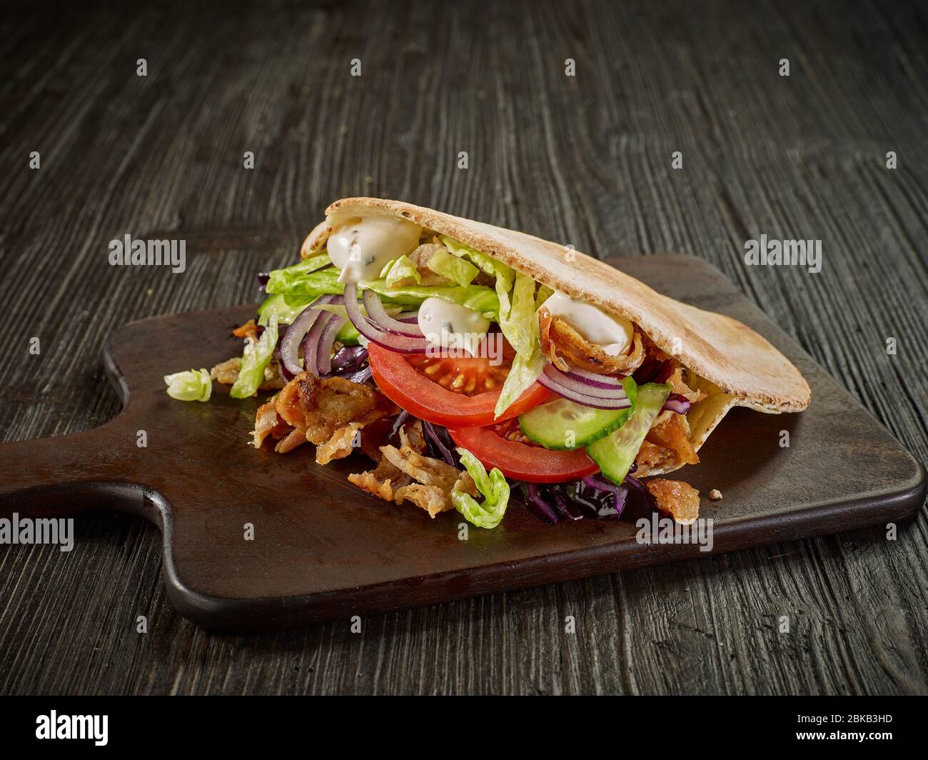 doner kebab on dark wooden kitchen table Stock Photo - Alamy