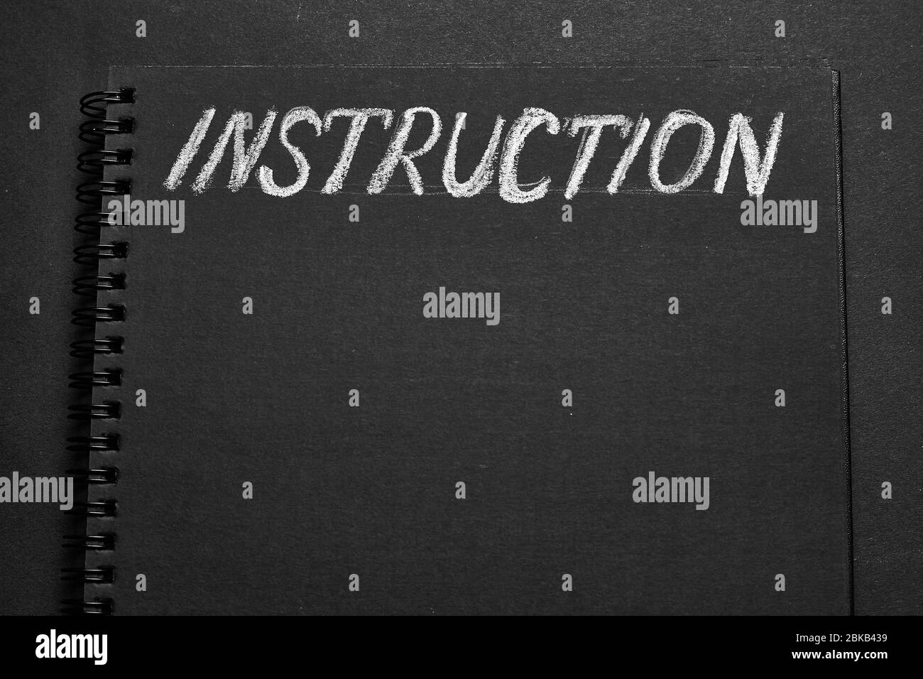 Instruction word written on a notepad with blank space. Blank black ...