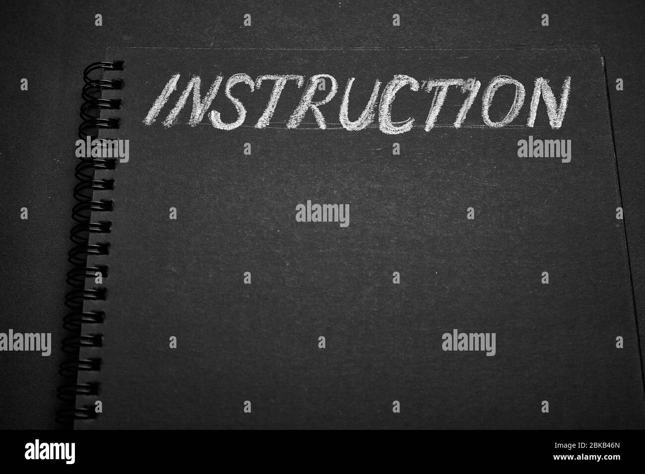 Instruction word written on a notepad with blank space. Blank black ...