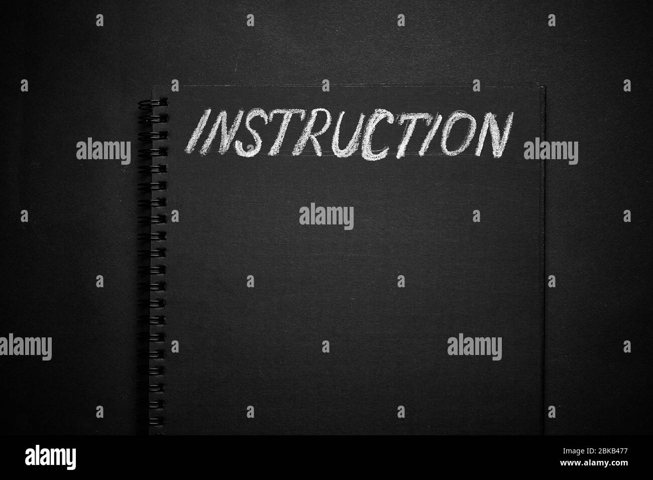 Instruction word written on a notepad with blank space. Blank black ...