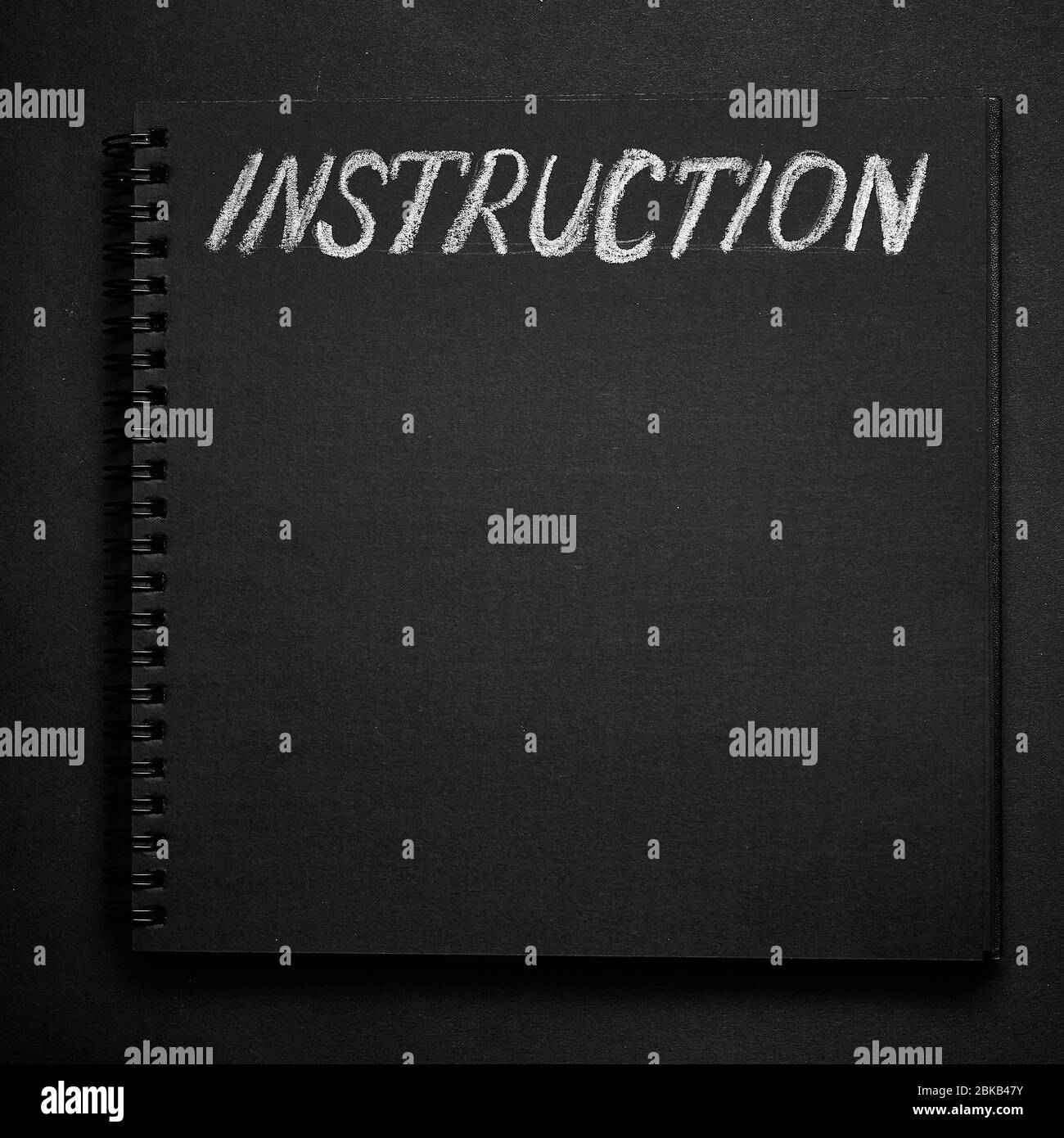 Instruction word written on a notepad with blank space. Blank black ...