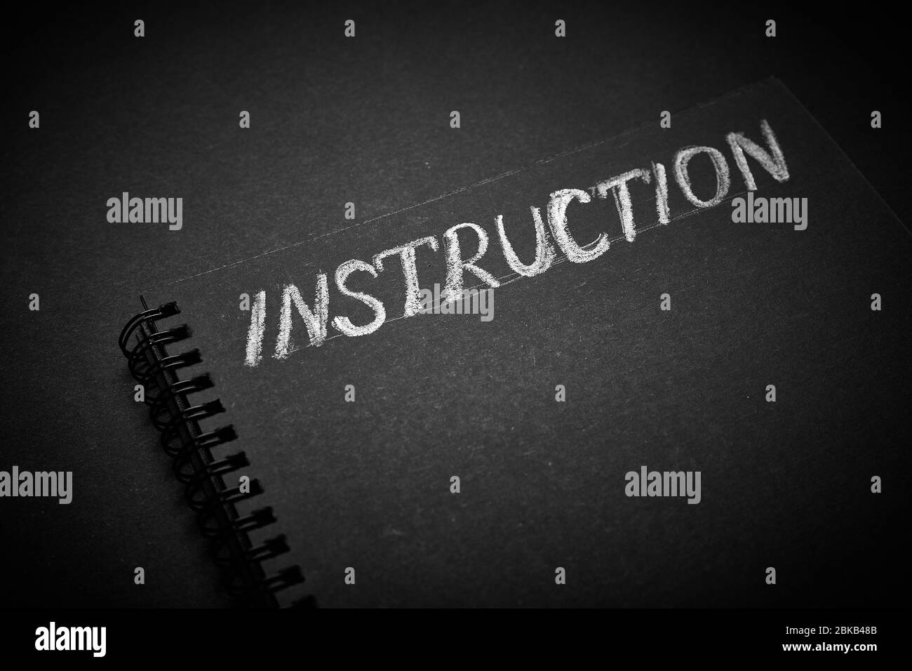 Instruction word written on a notepad with blank space. Blank black ...