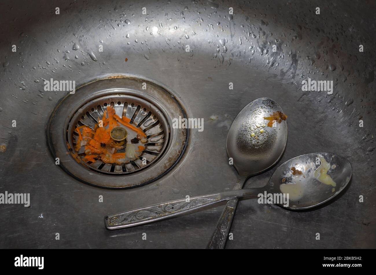 Dirty kitchen sink with spoons. Detailed shot of a metal sink with food ...