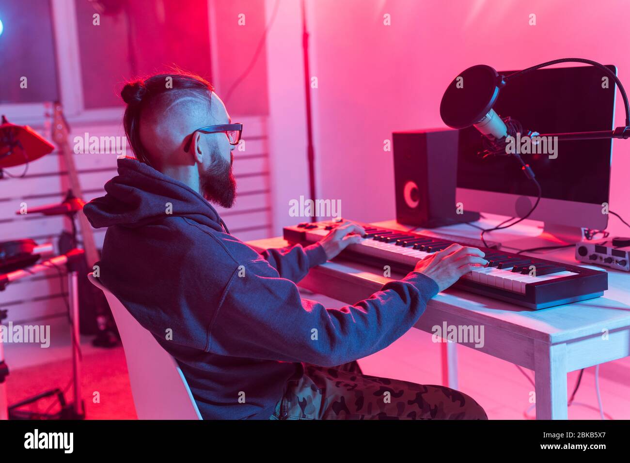 Professional musician recording synthesizer in digital studio at home ...