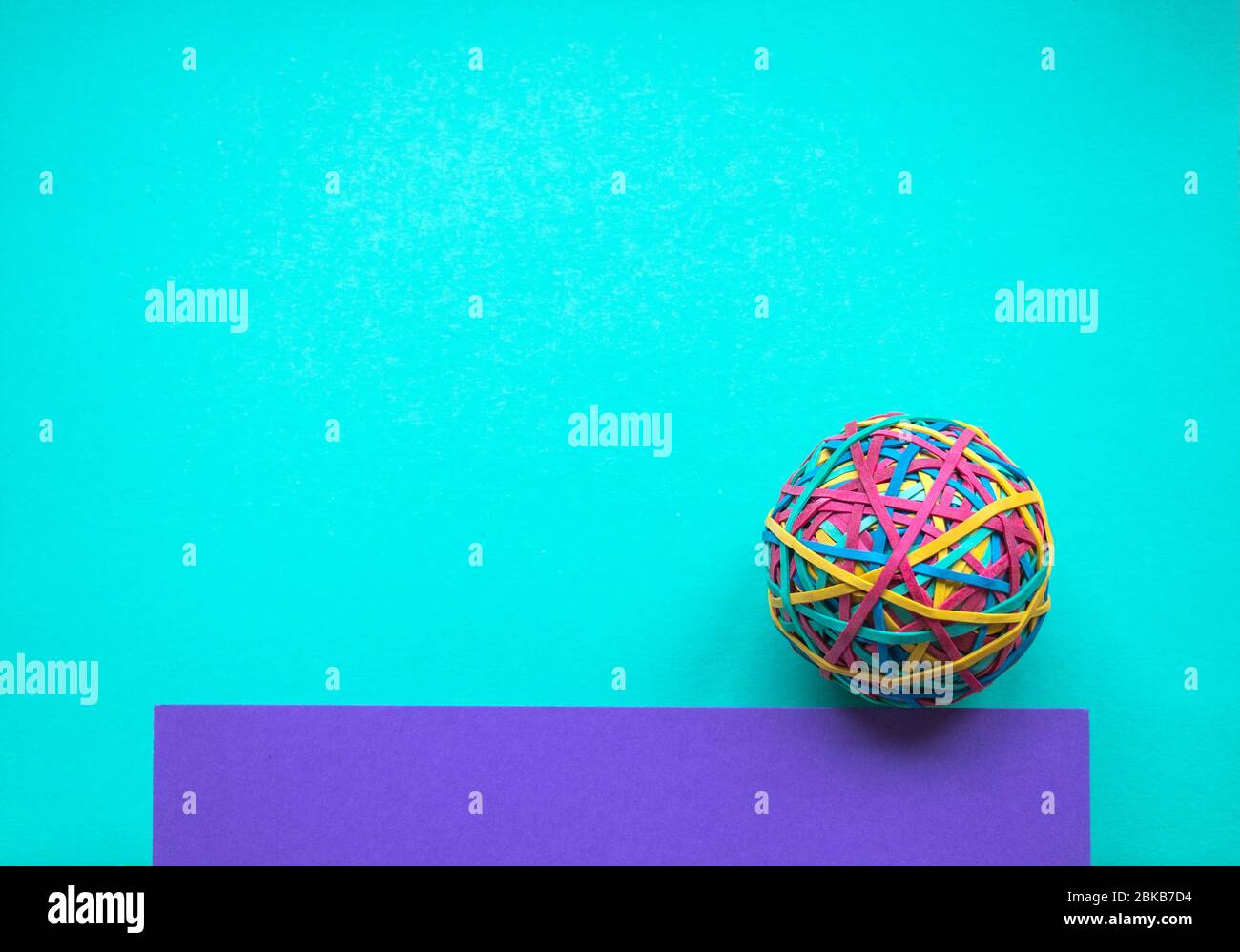 Rubber band ball on colored paper Stock Photo - Alamy