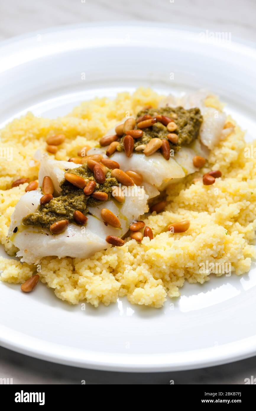 cod with green pesto and pine seeds with couscous Stock Photo - Alamy