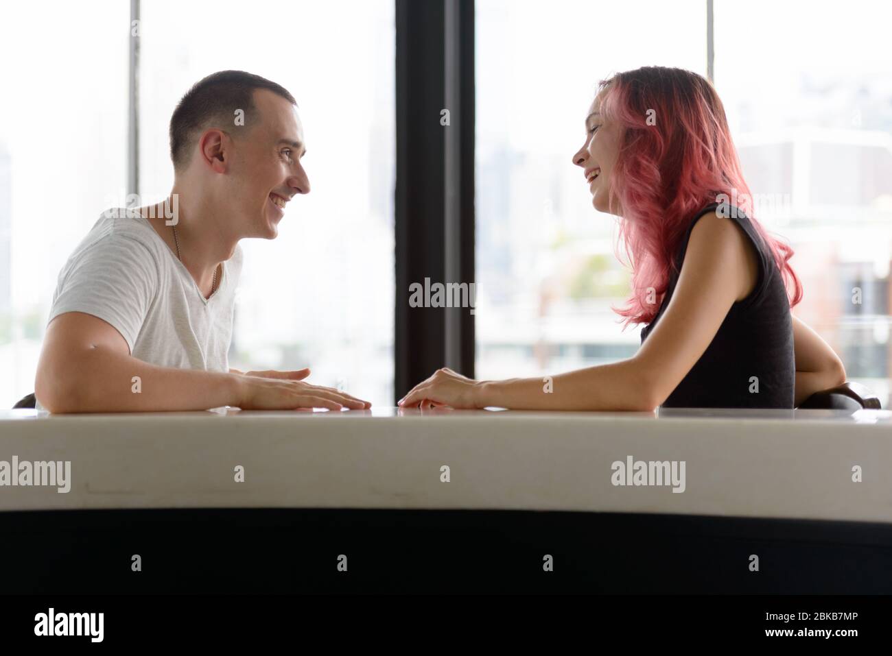 Portrait of happy couple talking together on the counter Stock Photo ...