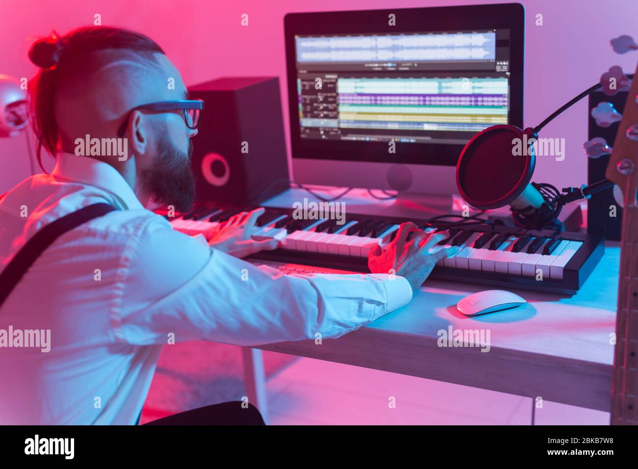 Professional musician recording synthesizer in digital studio at home ...