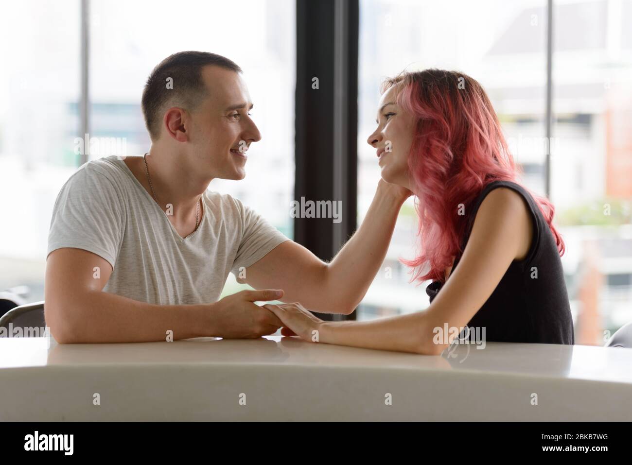Portrait of happy couple talking together on the counter Stock Photo ...