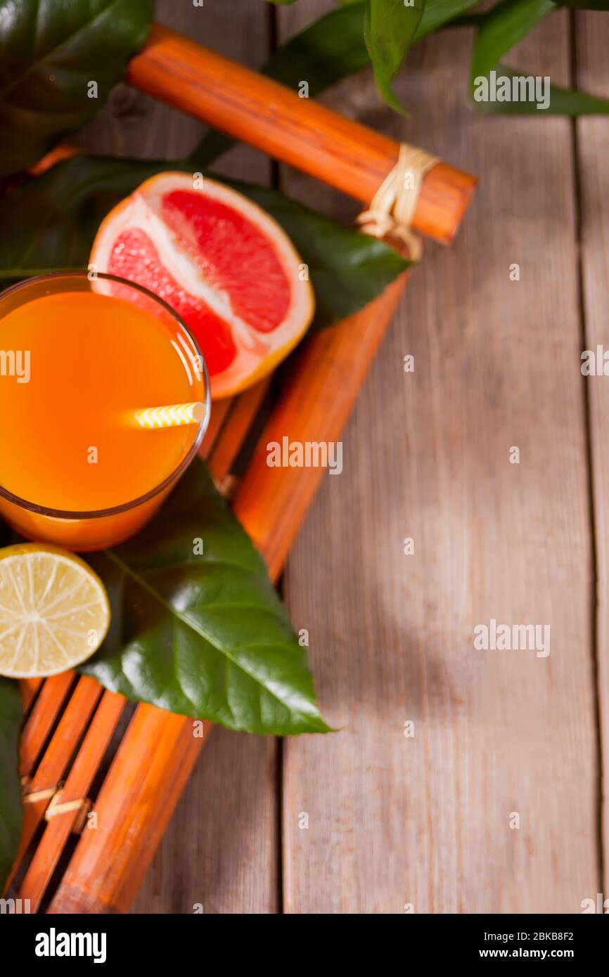 Glasses of tropical exotic multifruit juice and fruits on the wooden ...