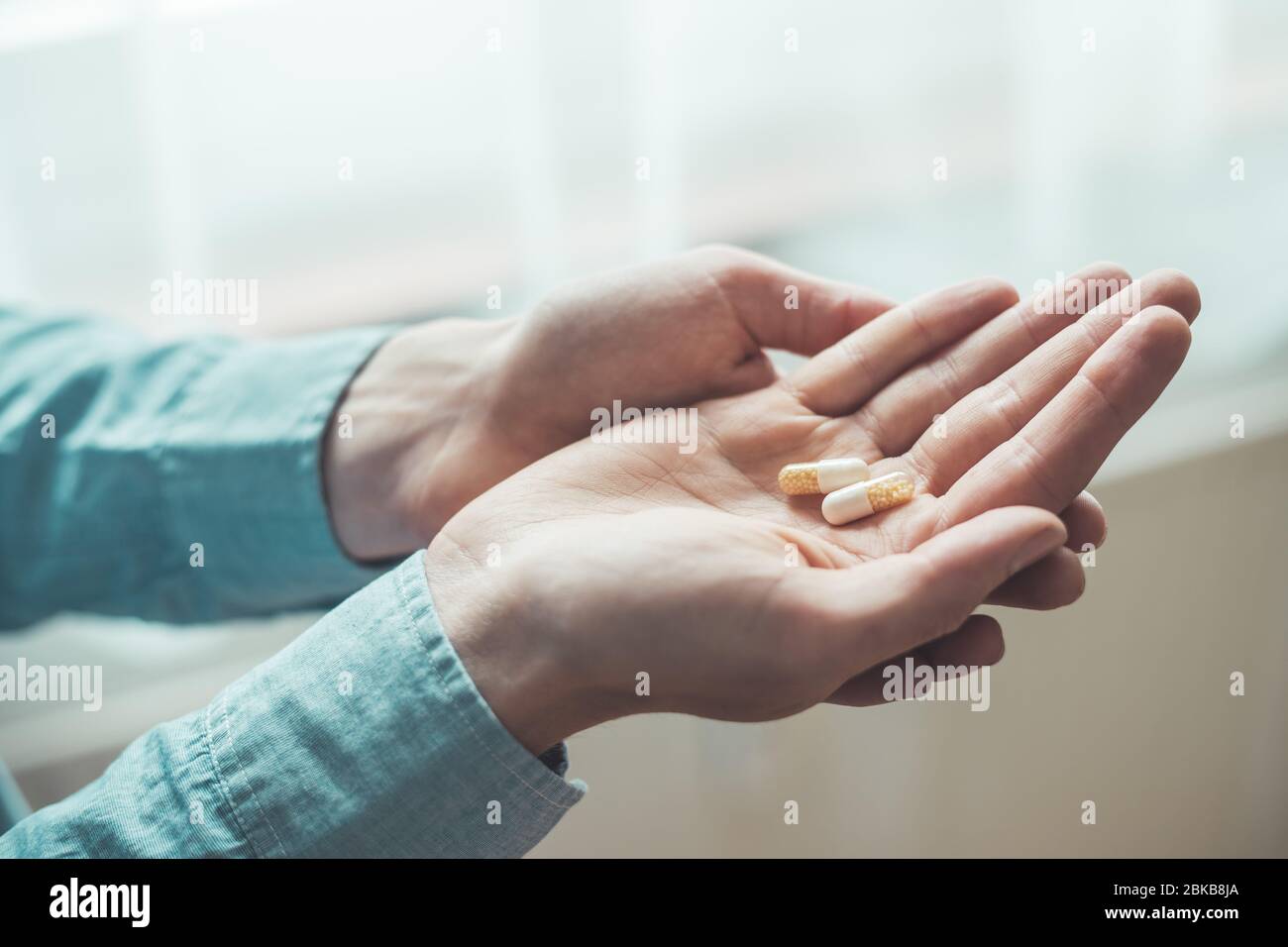 Male hand holding drug or vitamin pill in Stock Photo - Alamy