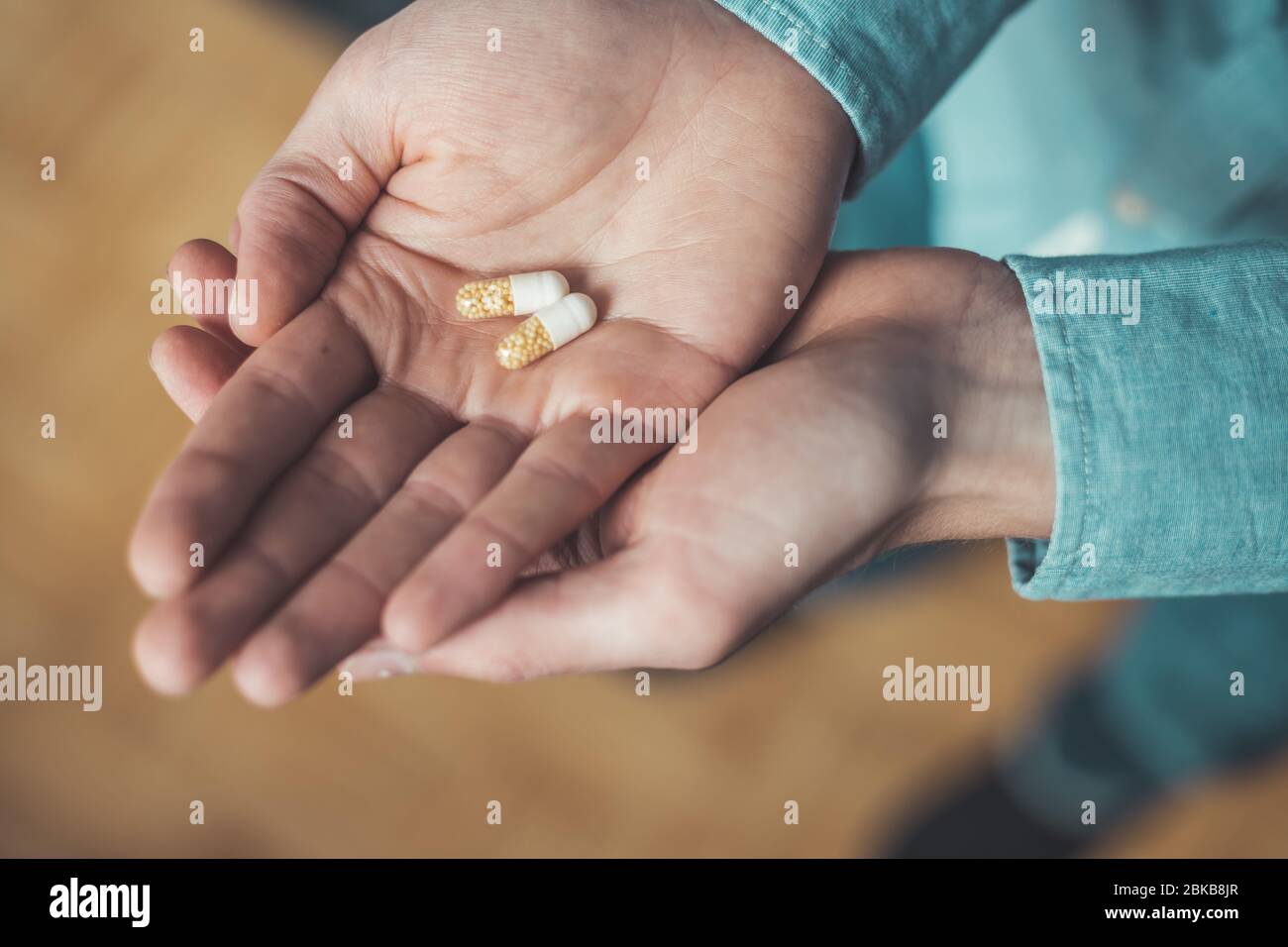 Male hand holding drug or vitamin pill in Stock Photo - Alamy