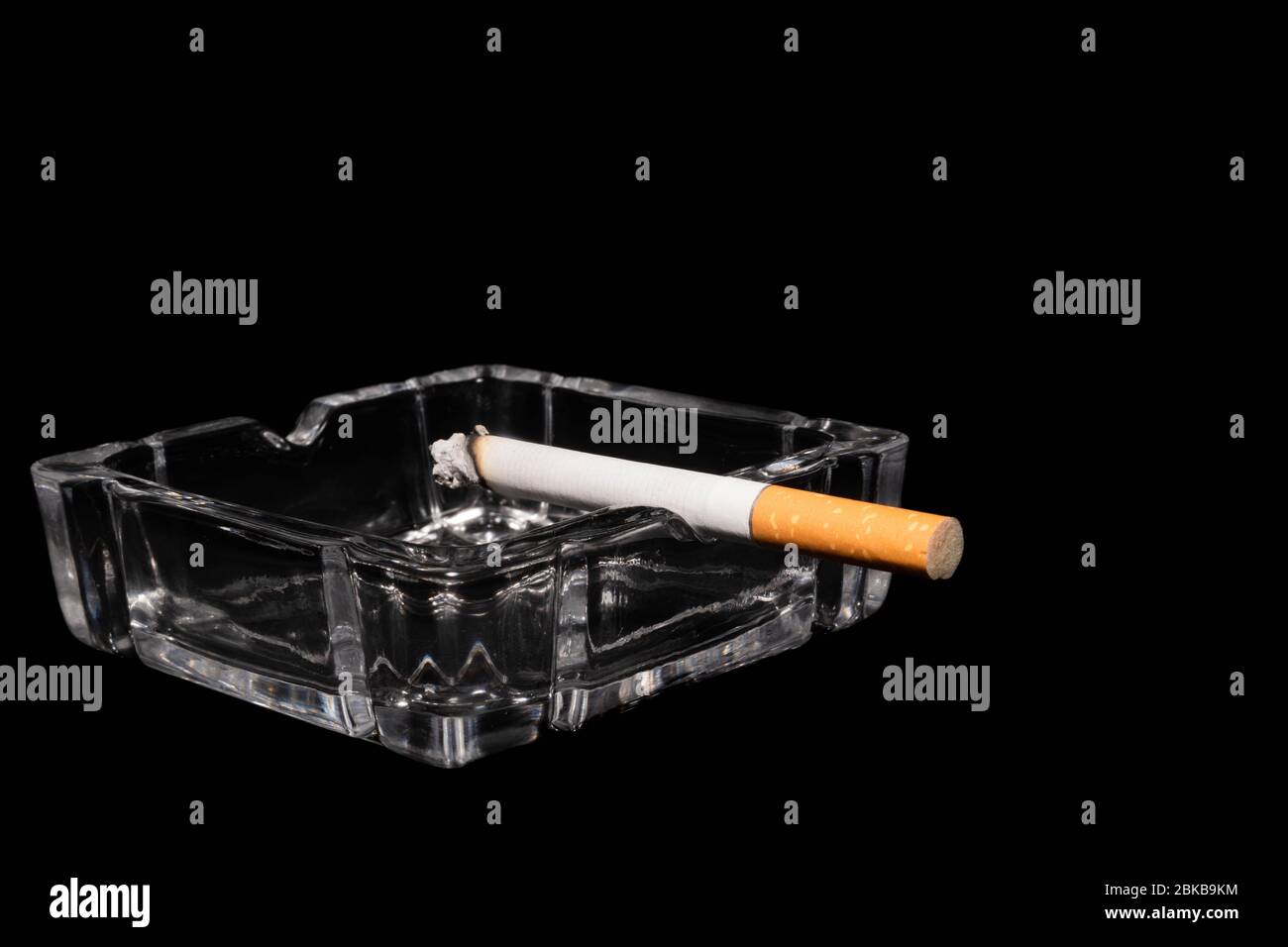 glass ashtray with burning cigar, black background Stock Photo - Alamy