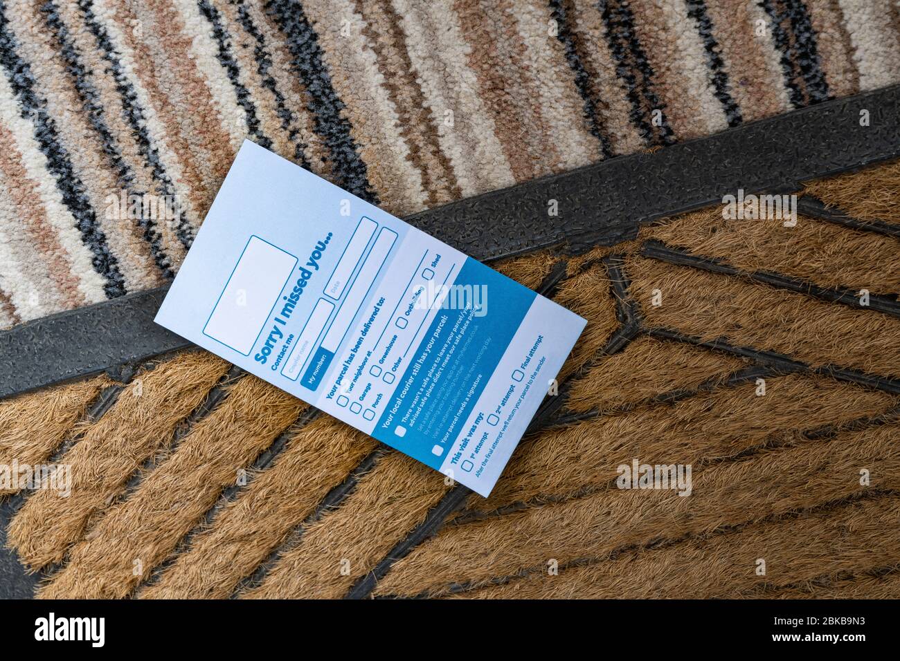 A parcel delivery sign laying on a doormat Stock Photo - Alamy