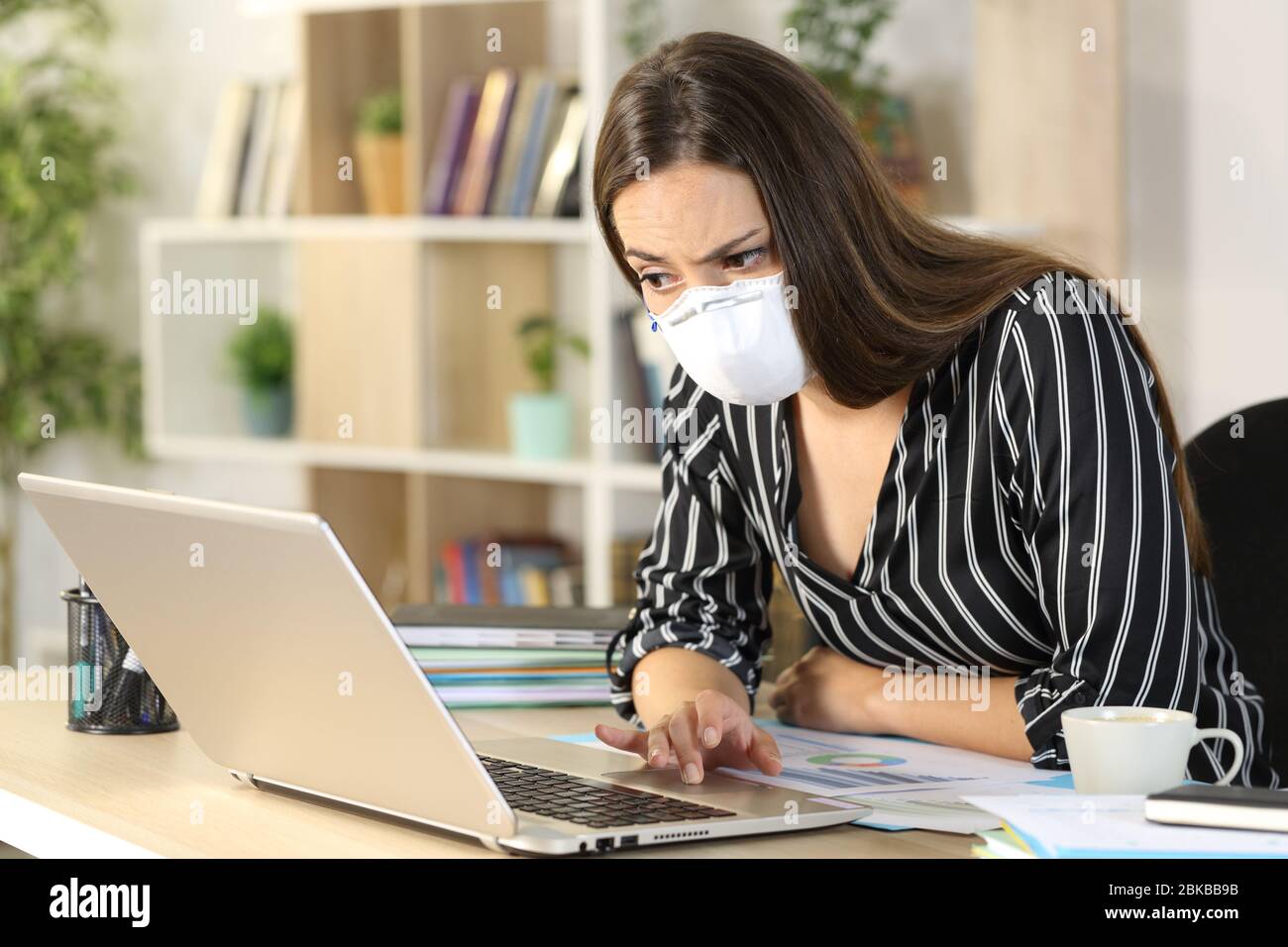 Suspicious entrepreneur woman reading fake news on laptop sitting on a ...