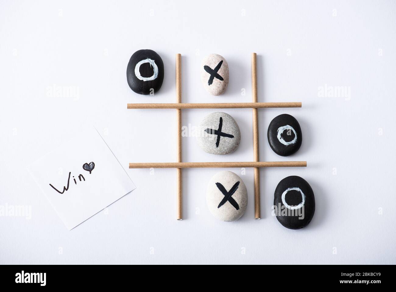 top view of tic tac toe game with grid made of paper tubes, pebbles ...