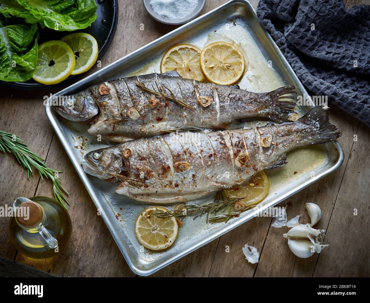 pan of baked fishes on wooden kitchen table, top view Stock Photo - Alamy