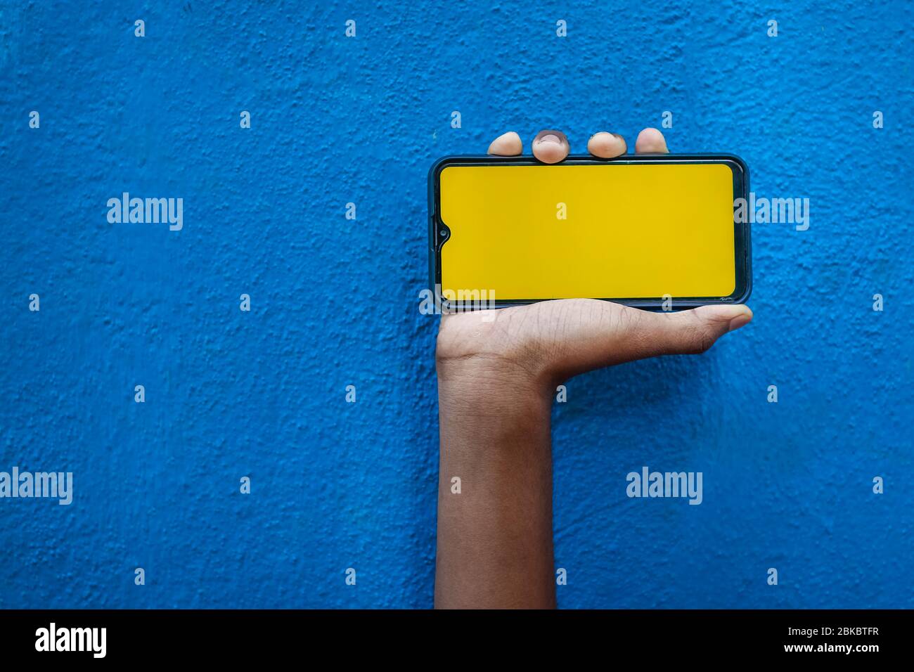Boy hand showing mobile smartphone screen in orange Color with Isolated ...