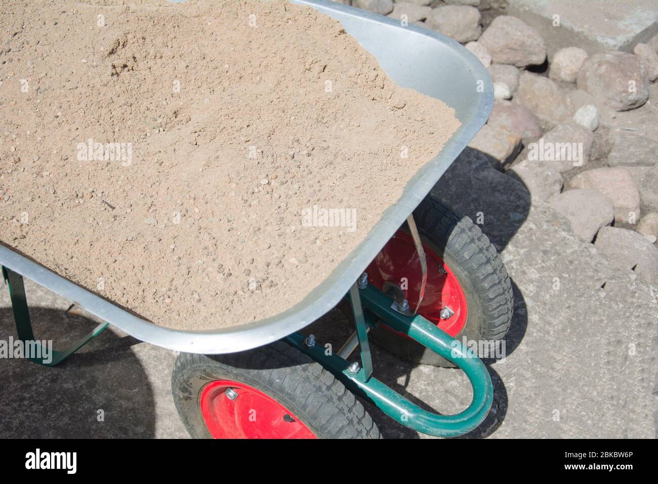 New metal wheelbarrow with sand on construction sites. For cement ...
