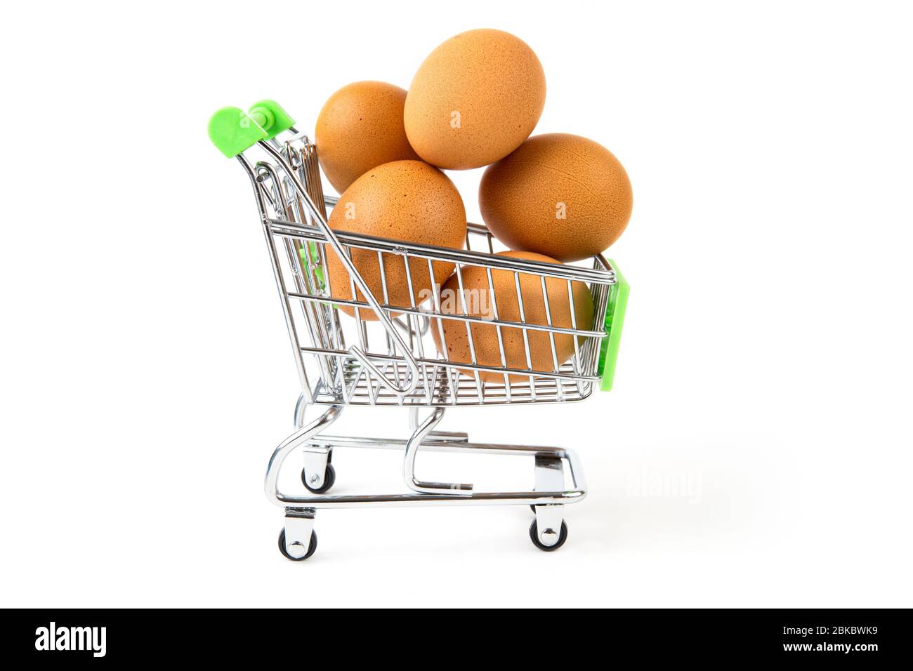 Chicken eggs in a miniature shopping cart isolated on white background ...