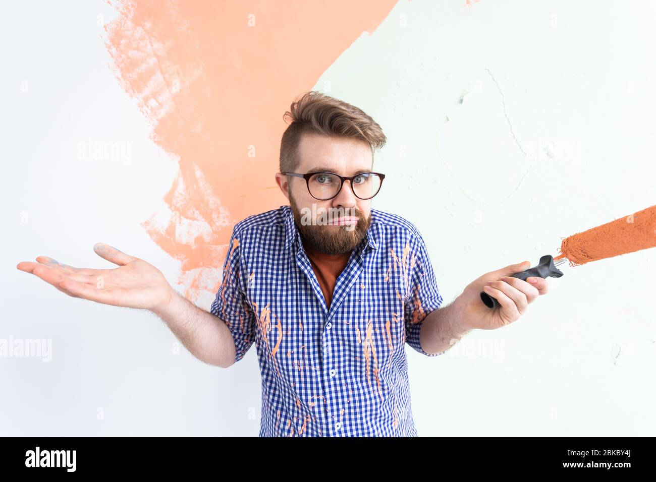 Confused man painting wall in her new apartment. Renovation and ...