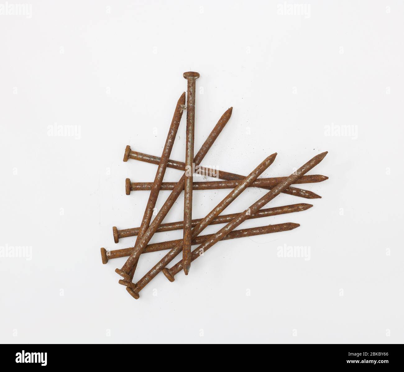Pile of long 6 inch rusty nails on white background with copy space ...