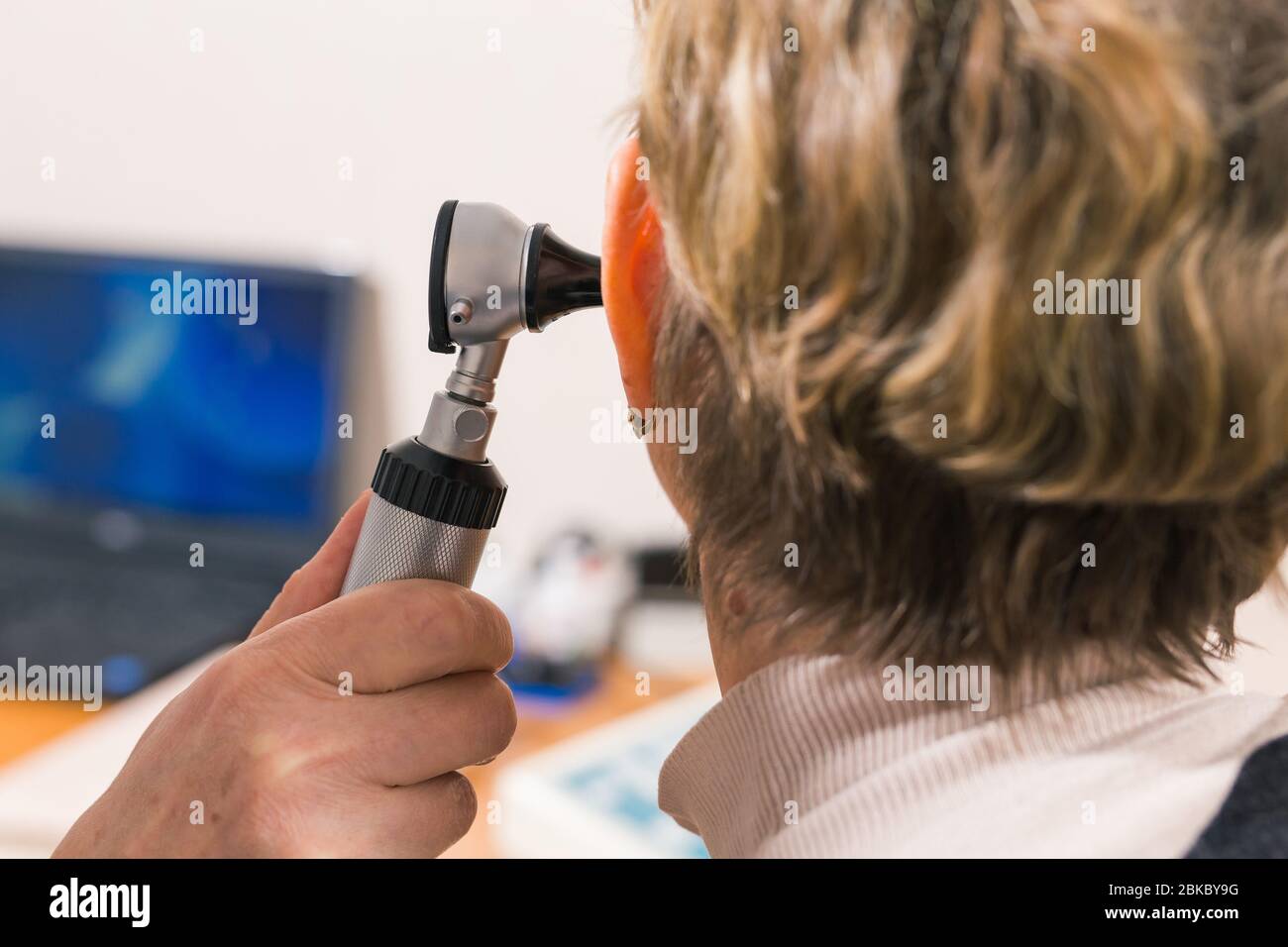 Doctor using otoscope instrument to check womans ear in hospital ...