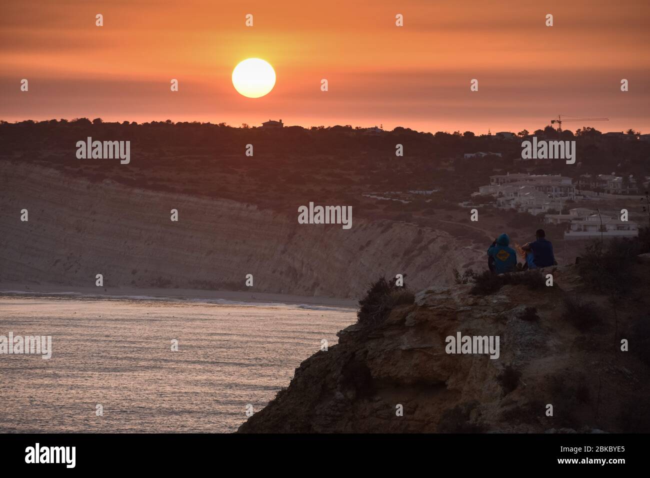Beautiful sunset over the cliffs of the beach, with a huge sun and the ...