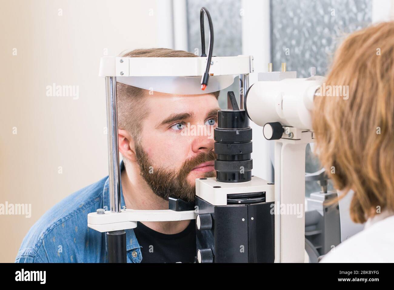 Medicine, health, ophthalmology concept - patient checks her vision by ...
