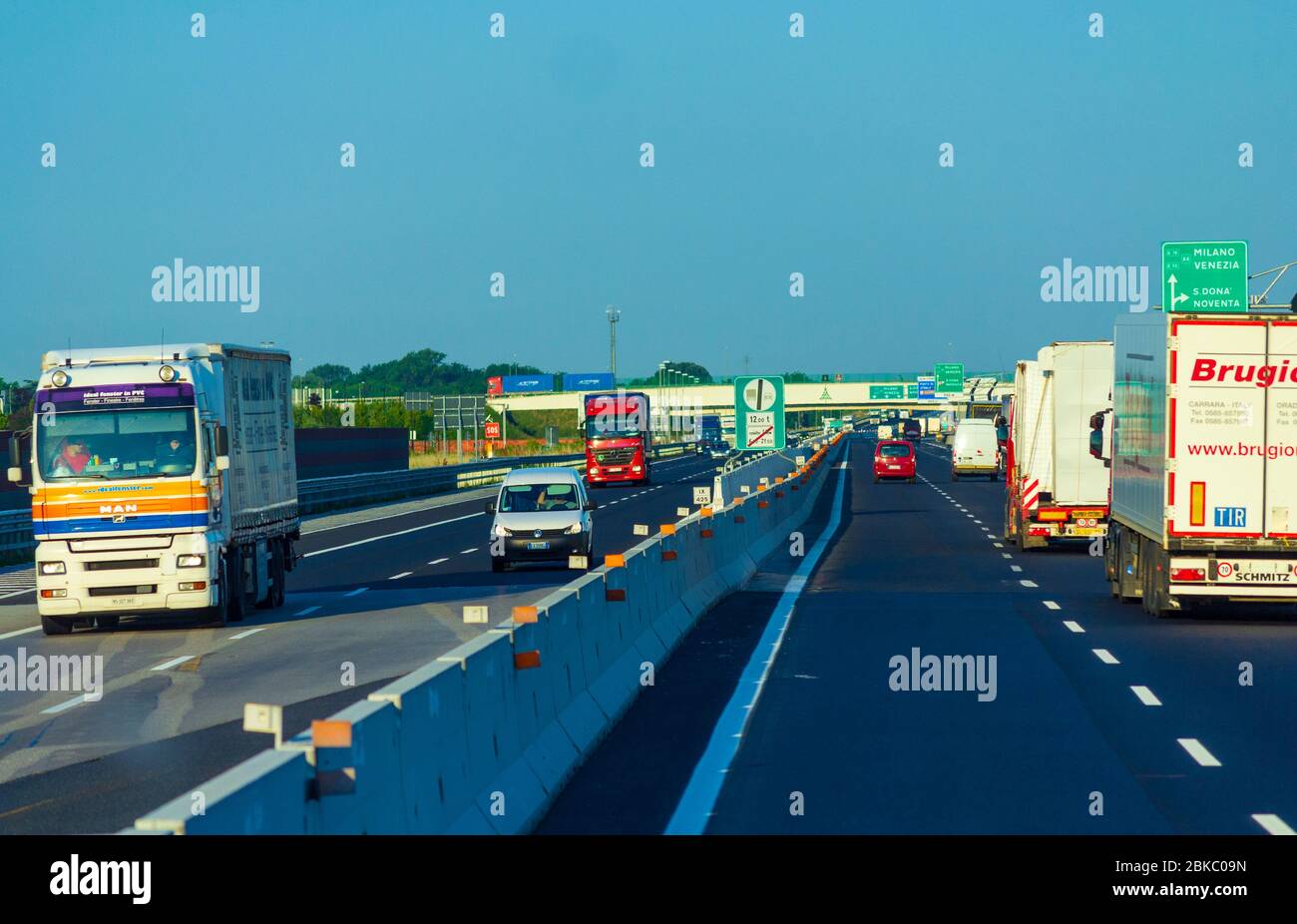 Heavy truck traffic at E70 European route or Italian Autostrada A4, or ...