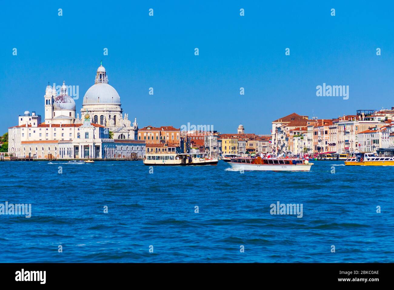 Summertime view of Venice lagoon with tour boats navigating and pier ...