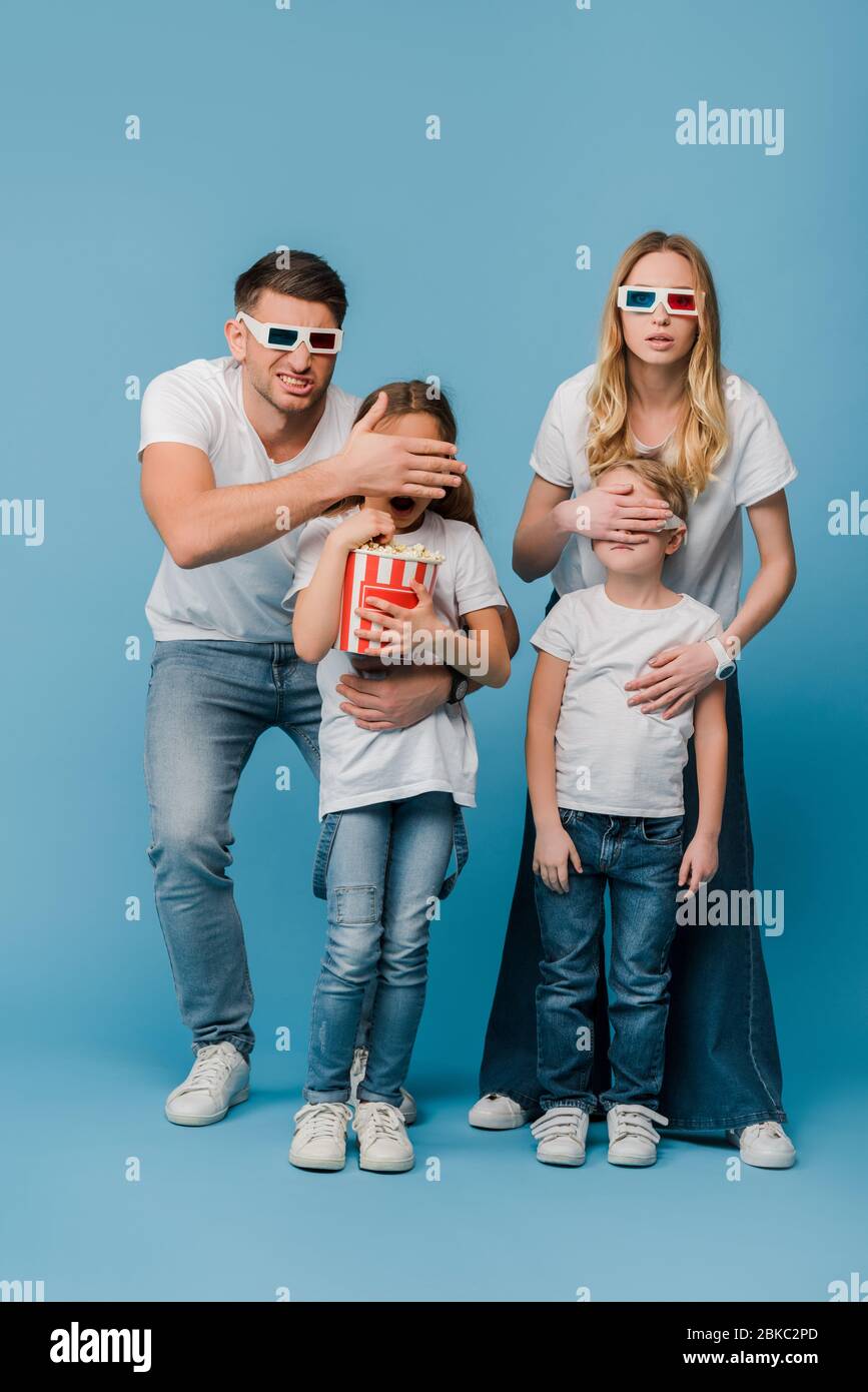 shocked parents in 3d glasses closing eyes to kids holding popcorn ...
