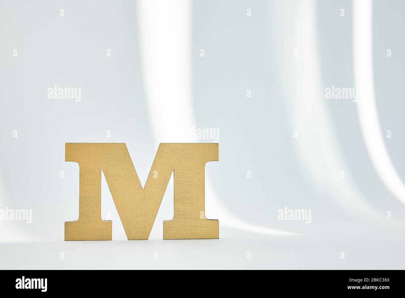 m letter on white background with sunlight Stock Photo - Alamy