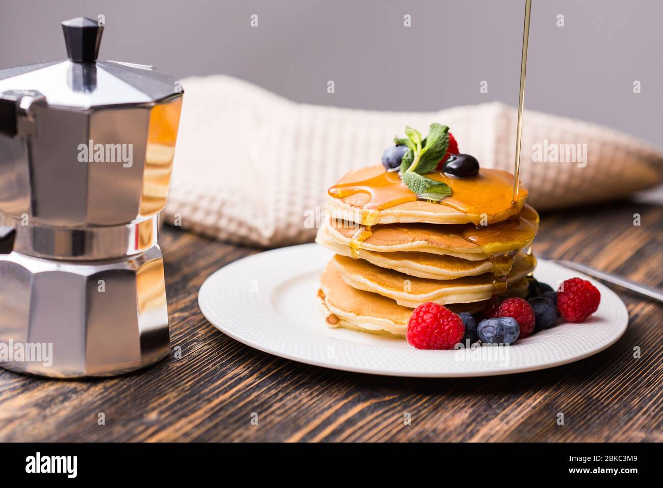 Maple syrup pouring over a stack of mini pancakes Stock Photo - Alamy