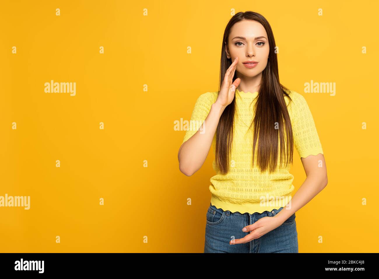 Beautiful woman using sign language on yellow background Stock Photo ...