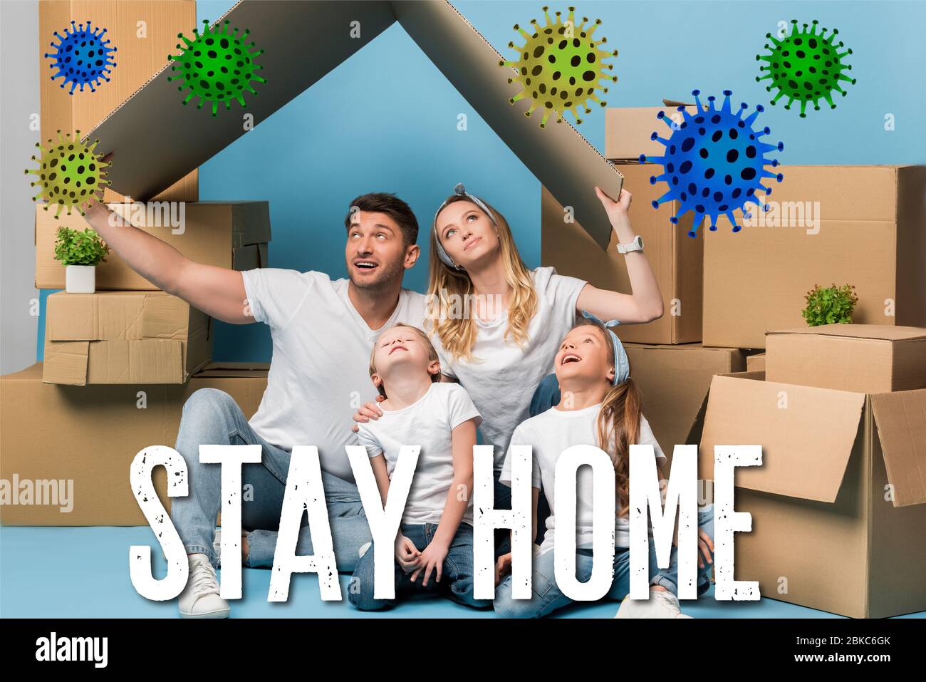 happy parents holding carton roof over kids on blue with cardboard ...