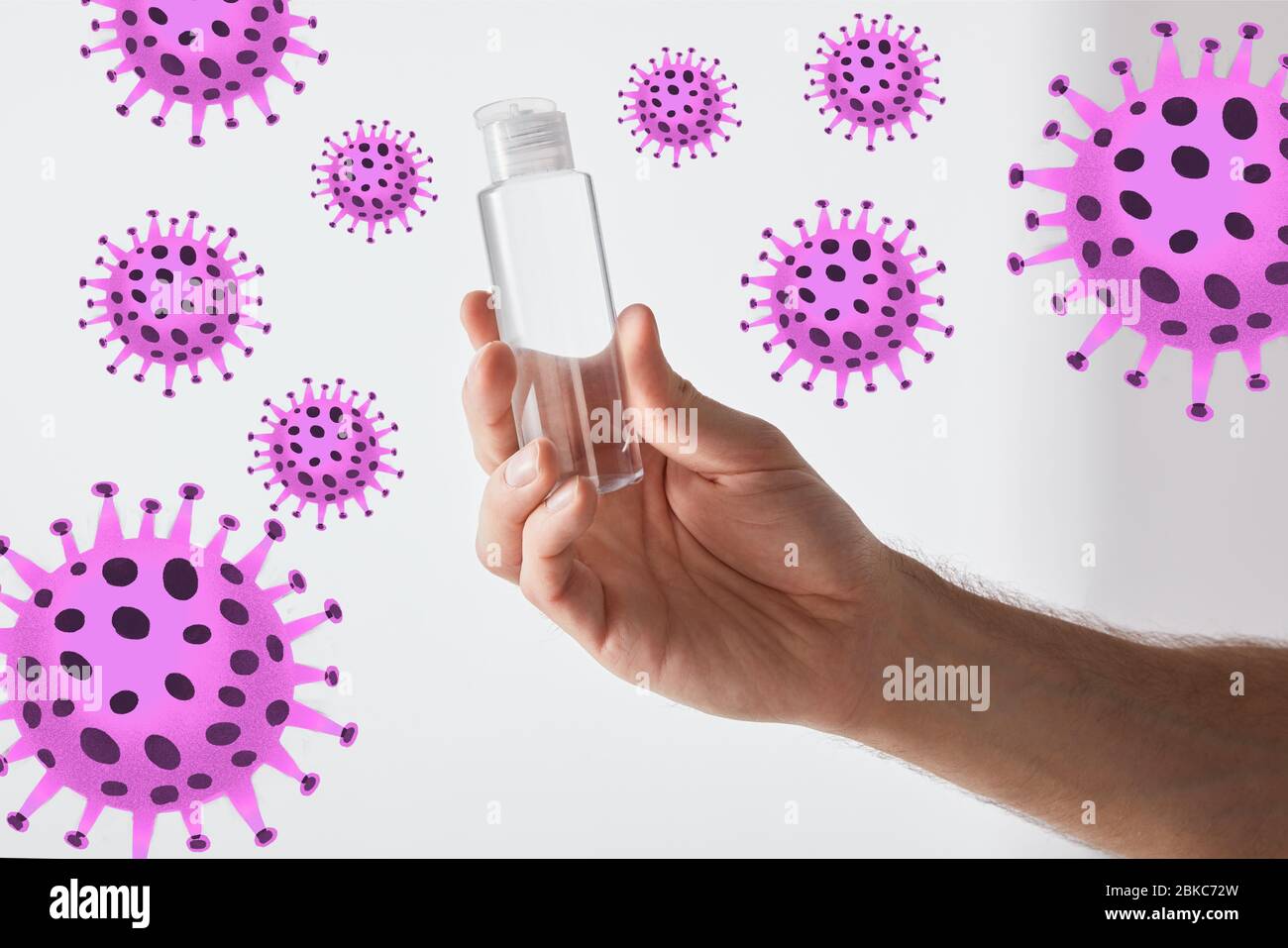 cropped view of man holding hand sanitizer on grey background, bacteria ...
