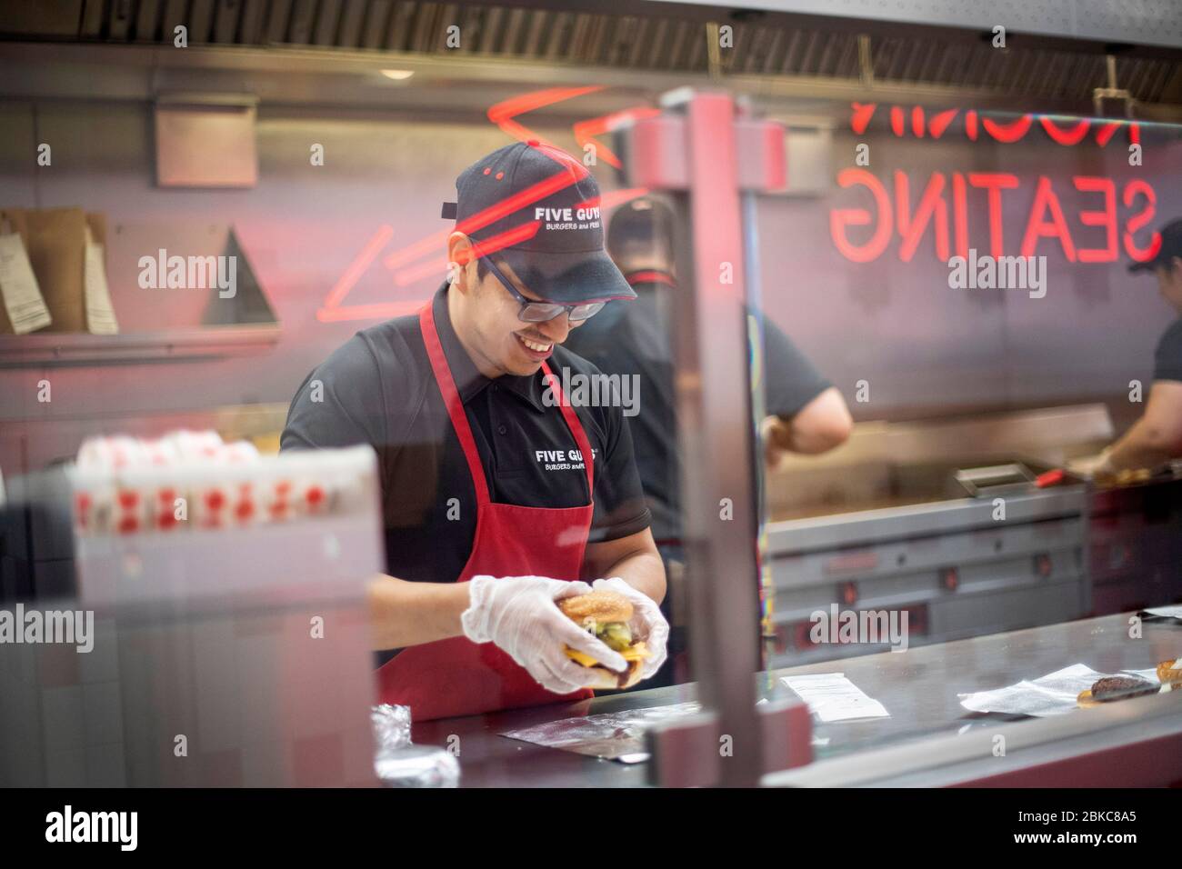 Workers prepare orders in five guys restaurant in kensington hi-res ...