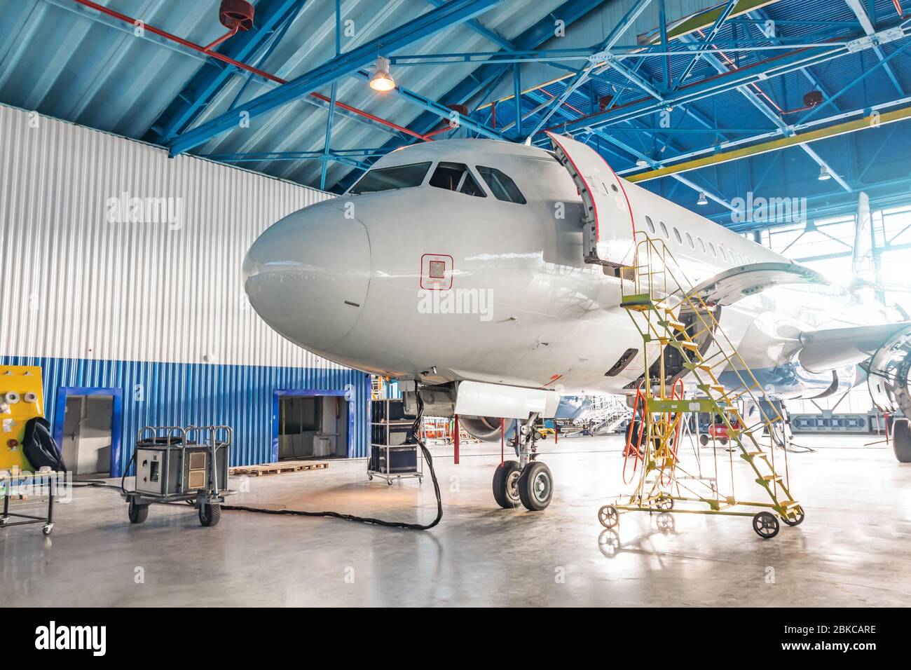 Airplanes under repair in a maintenance hangar. View of the nose and ...
