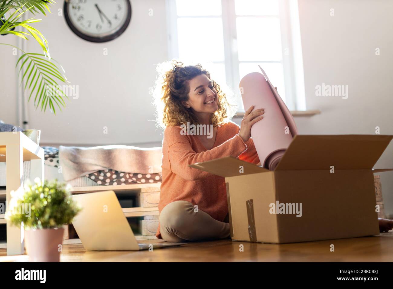 Woman unpacking box with workout equipment at home Stock Photo - Alamy