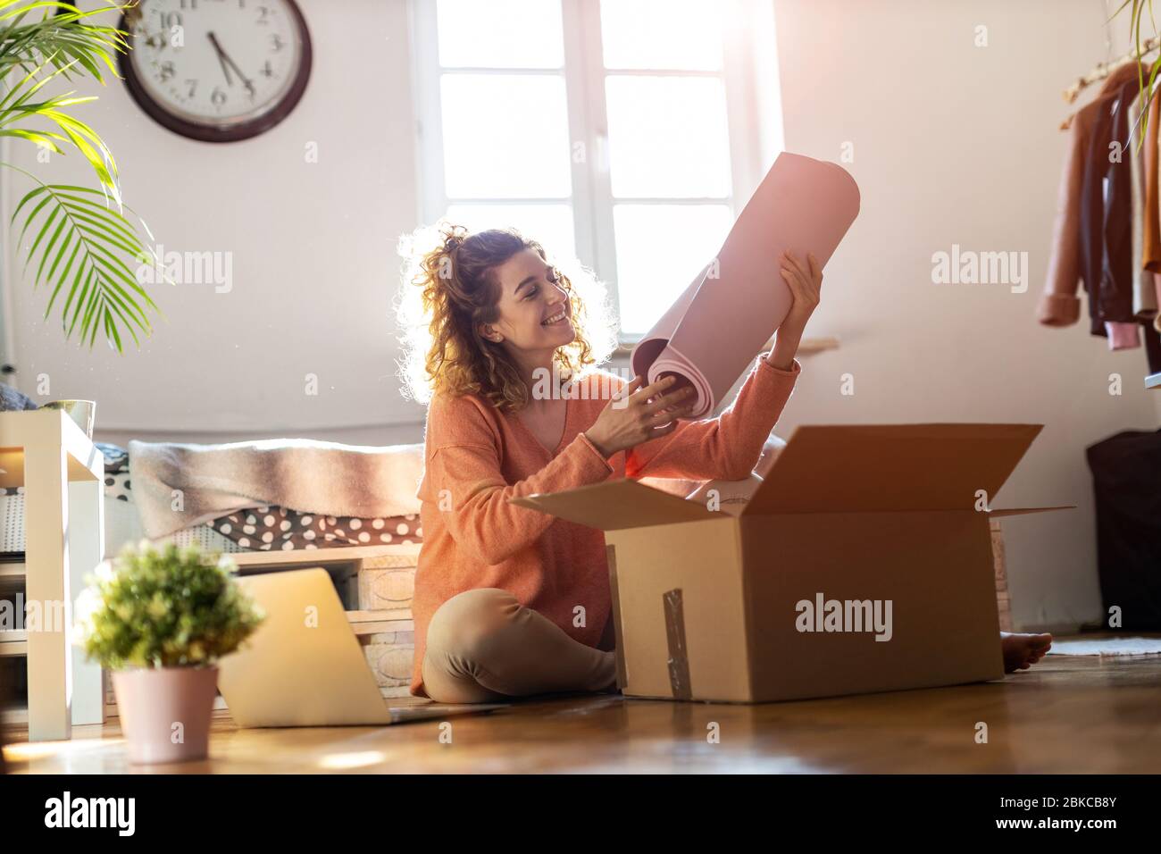 Woman unpacking box with workout equipment at home Stock Photo - Alamy