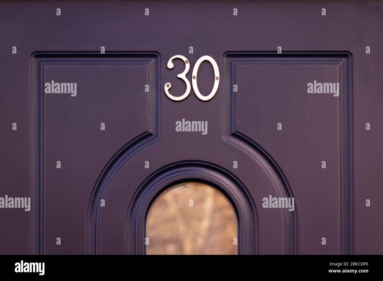 House number 30 on a dark wooden front door with rounded carvings Stock ...