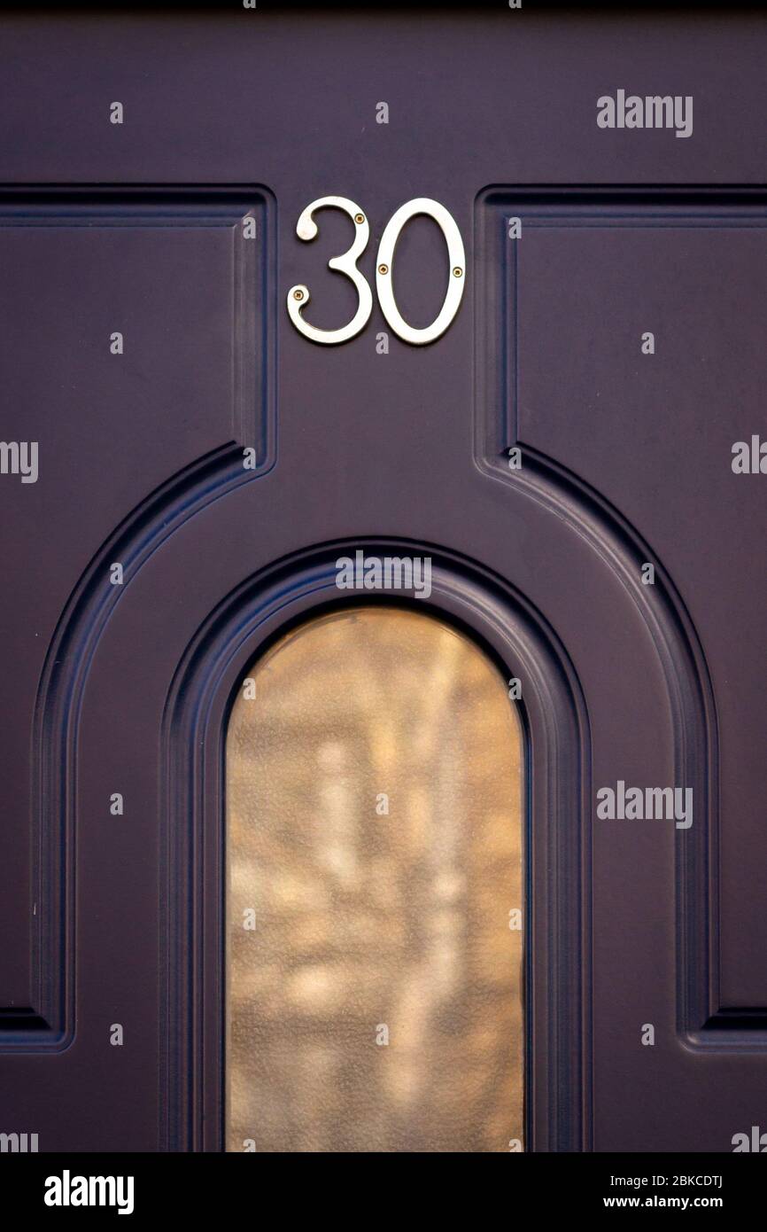 House number 30 on a dark wooden front door with rounded carvings Stock ...